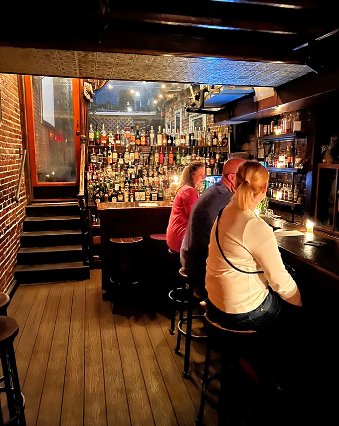 Customers: Patrons savor handcrafted libations at the bar, where bottles glow like treasure and every conversation feels like it could change history.