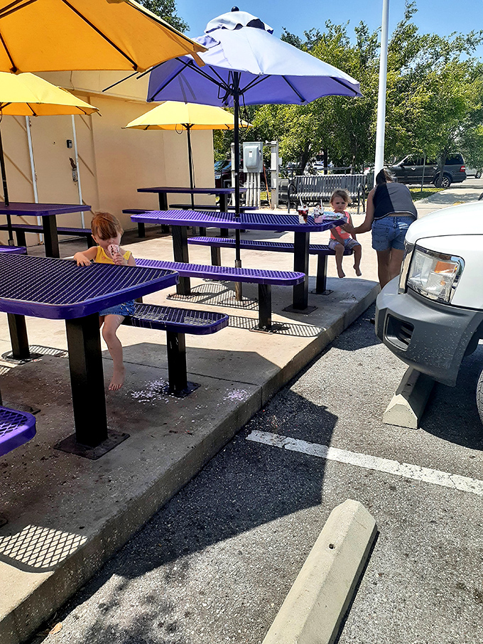 Purple tables under cheerful umbrellas &ndash; where strangers become comrades in the battle against melting ice cream.