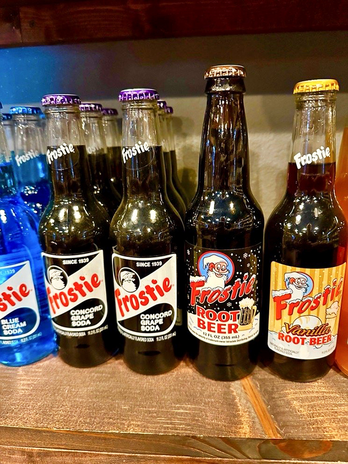 Frostie sodas line up like colorful soldiers of refreshment, their glass bottles promising flavors that somehow taste better than their modern counterparts.
