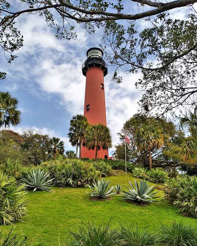 Standing sentinel since 1860, this crimson tower rises dramatically above lush tropical vegetation, creating Jupiter's most photographed and beloved landmark.