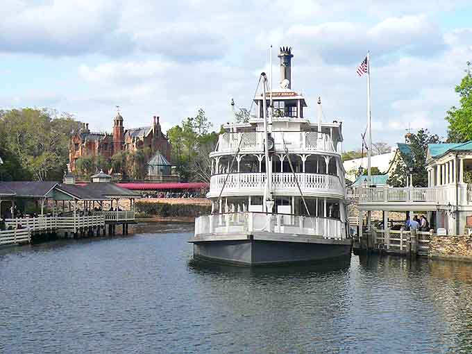 The Liberty Belle Riverboat glides across calm waters, offering weary park-goers a chance to rest their feet while pretending to be Mark Twain.