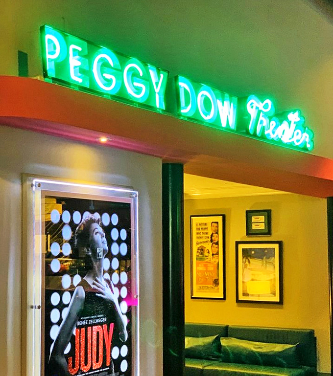 The Peggy Dow Theater's glowing green neon sign invites film lovers into an intimate space where cinema is celebrated in style.