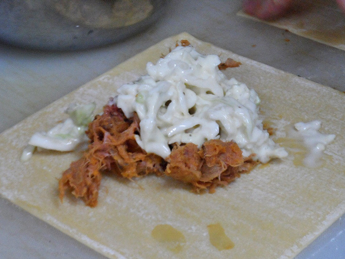 Pulled pork nestled in coleslaw awaits its tortilla wrap transformation &ndash; proof that good things come in aluminum foil packages.