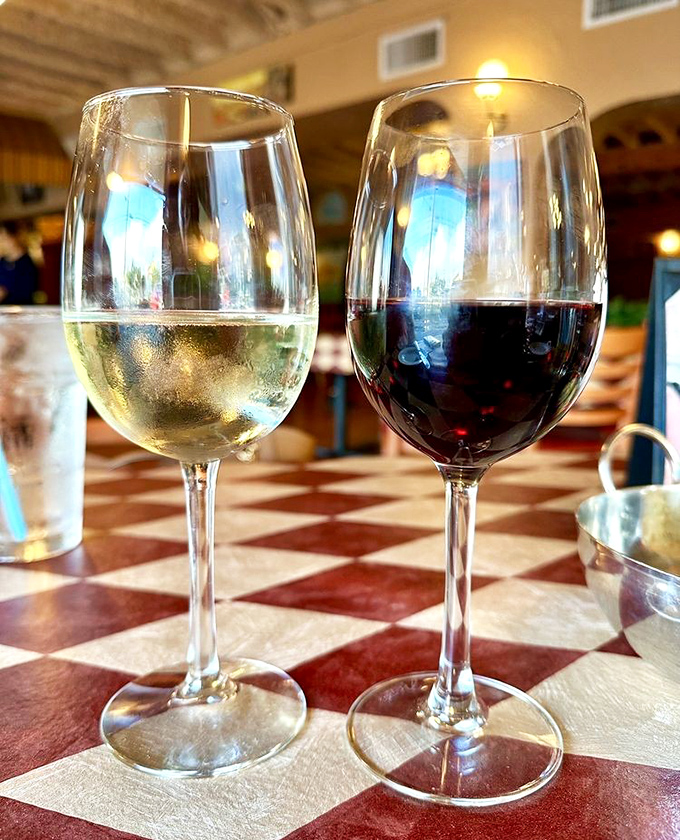 Wine glasses catch the warm restaurant lighting, promising the perfect complement to your Italian feast.