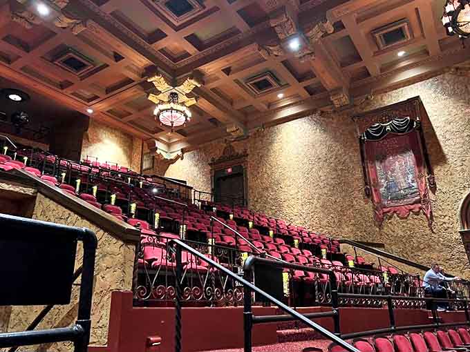 Rich red seats cradle generations of theatergoers, each with their own stories, creating a tapestry of shared experiences across nearly a century.