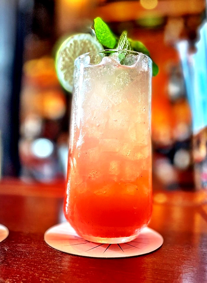  This isn't just a drink; it's a sunset in a glass&mdash;layers of crimson and gold topped with fresh mint and lime, promising refreshment with a hint of mischief.
