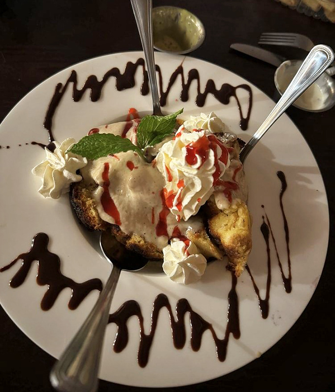 Dessert that defies gravity – strawberry shortcake bread pudding adorned with whipped cream and artistic chocolate drizzles that make saying "no" impossible.
