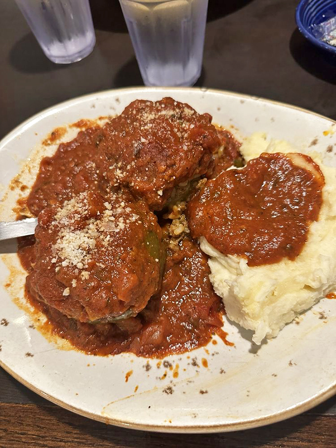 Stuffed peppers swimming in rich tomato sauce alongside cloud-like mashed potatoes &ndash; comfort food that hugs you from the inside out.