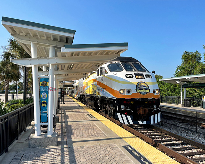Passengers disembark at a sun-drenched station, stepping from air-conditioned comfort into another uniquely Floridian community waiting to be explored.