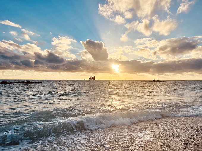 Sunset shot: The golden hour transforms ordinary waters into liquid amber while sailboats cut silhouettes against the fading light.