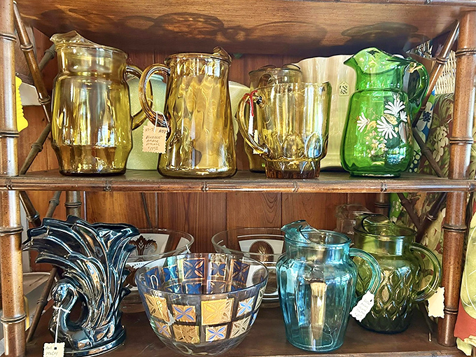 Sunlight dances through colored glass pitchers and vases, creating a rainbow effect that showcases their mid-century craftsmanship and design.