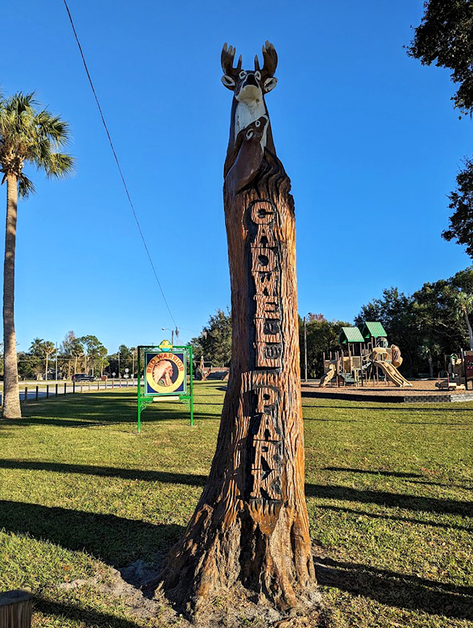 A towering tree trunk becomes "Gateway Park," crowned by a noble buck whose antlers reach skyward like a natural monument.