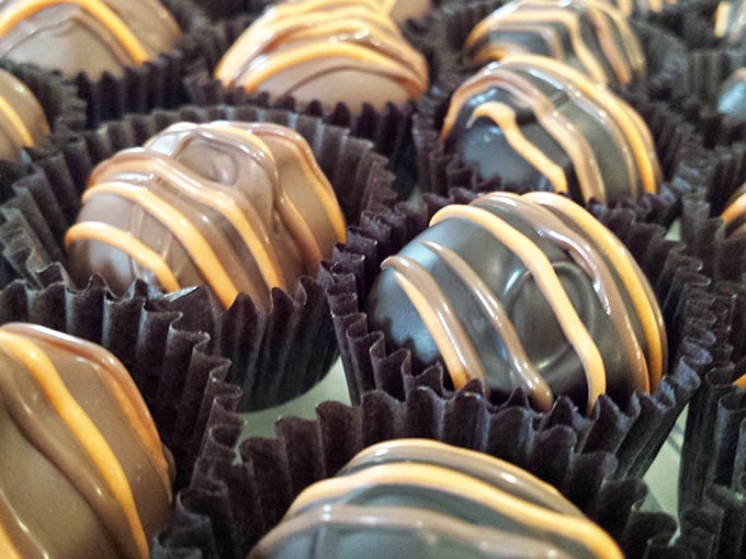 A hand holds up a towering chocolate-dipped ice cream cone, the ultimate summer indulgence against a backdrop of memorabilia.