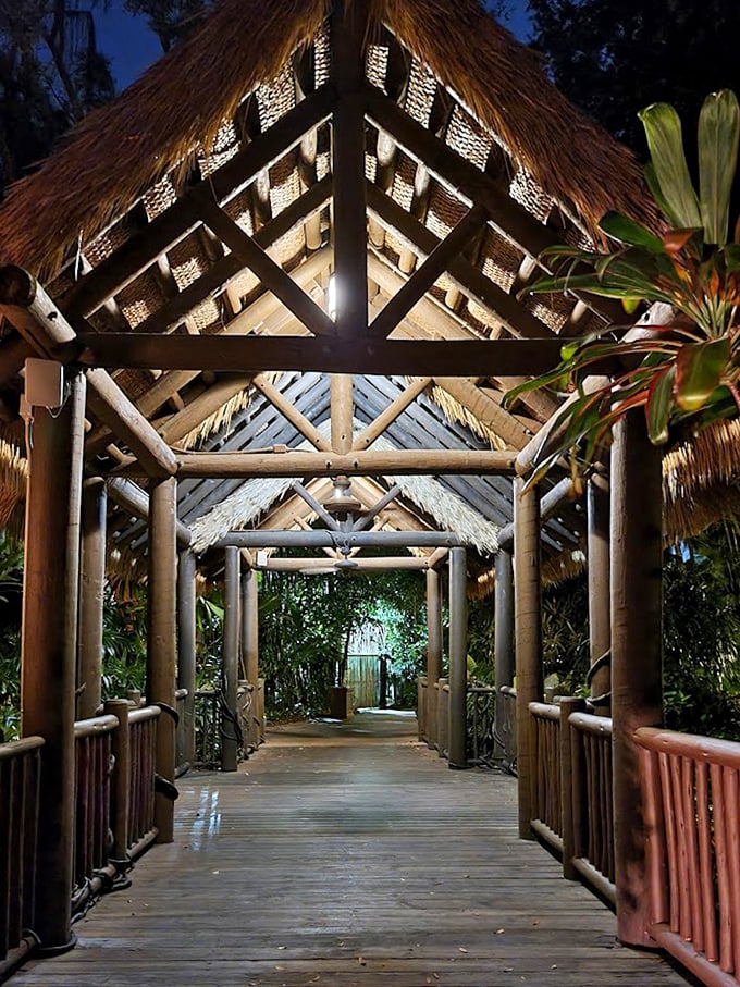 This bamboo walkway leads visitors into a world of wonder, its thatched roof creating dappled light patterns like nature's own welcome mat.