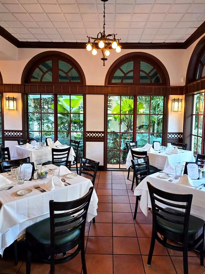 Arched windows flood the dining room with natural light while elegant wood accents and classic table settings create an ambiance that's both sophisticated and comfortably familiar.