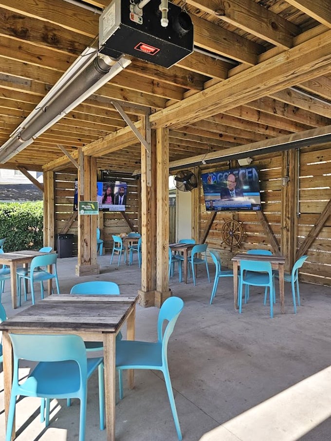 Rustic wooden beams frame the airy dining space where turquoise chairs add pops of coastal color to the relaxed setting.