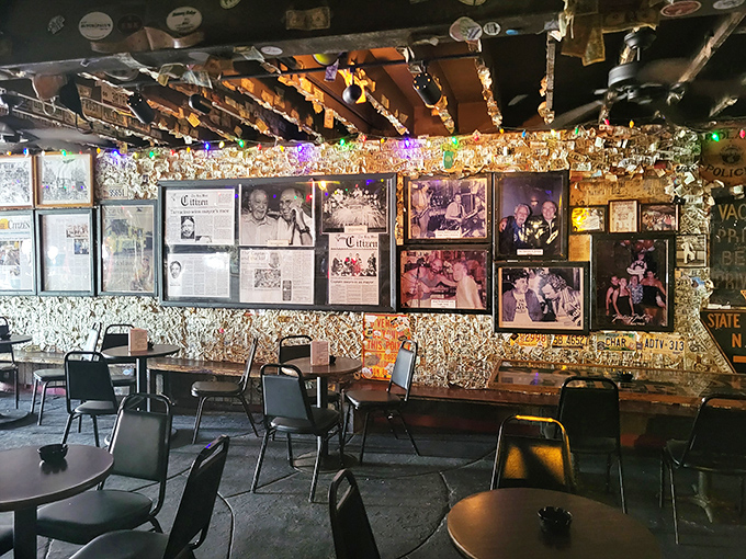 Framed photographs and news clippings create a visual timeline of the saloon's colorful history and famous visitors.
