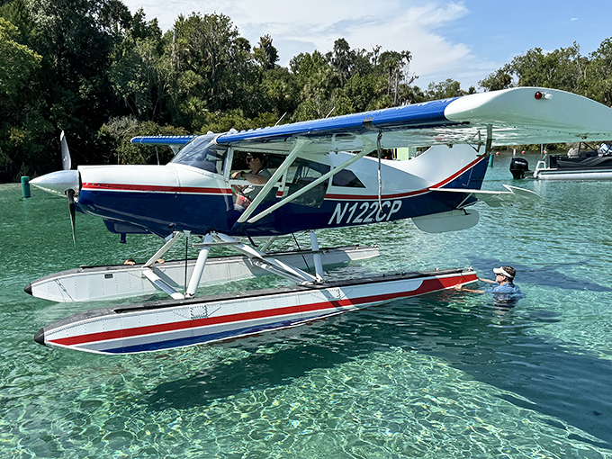 A floatplane rests on water so pristine it's hard to tell where aircraft ends and reflection begins.