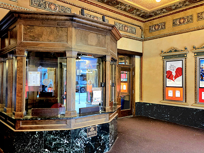 The ticket booth stands like a time capsule, where marble meets mahogany in a transaction space worthy of royalty.