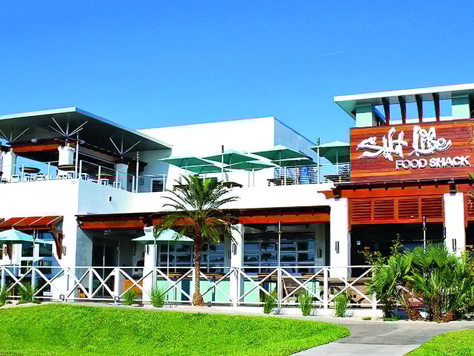 Salt Life Food Shack's bright, modern exterior welcomes beach lovers with its clean lines and tropical landscaping. A perfect post-surf dining destination!