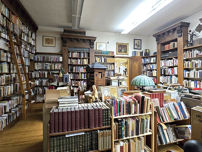 Organized chaos reigns in this corner where books stack horizontally and vertically, creating a three-dimensional puzzle of literary possibilities.