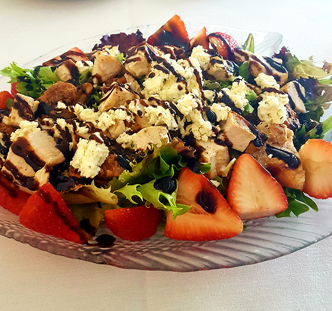 A colorful chicken salad studded with strawberries and blue cheese offers a lighter option without sacrificing flavor. Fresh ingredients arranged with artistic flair.