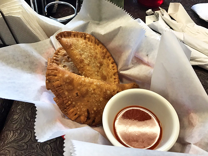 Golden-brown chicken patties with flaky crusts hiding seasoned treasures inside &ndash; the Caribbean's answer to comfort food in portable form.