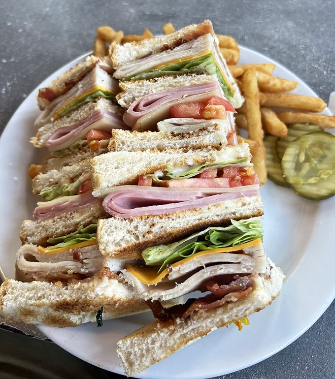 Club sandwich architecture at its finest&mdash;layers of meat and veggies stacked between toast, with golden fries standing at attention.