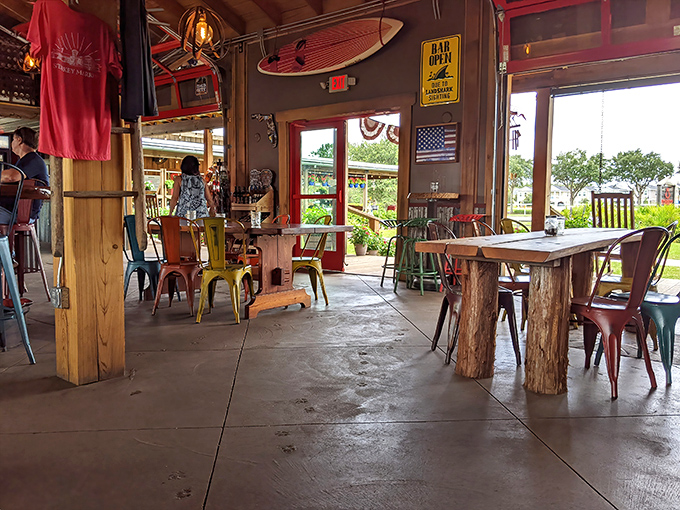 Colorful metal chairs pop against wooden tables and concrete floors &ndash; industrial meets farmhouse in this inviting space.