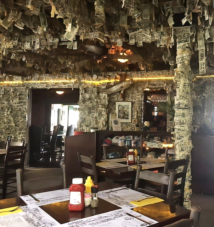 Another angle of the dining area shows how completely the dollar bill tradition has taken over, creating a uniquely immersive dining environment.