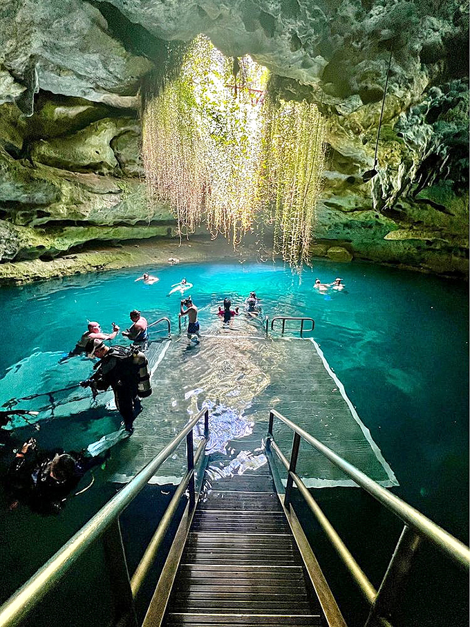 Dive Platform with Swimmers: Adventurers gather at the underwater stage, where prehistoric waters host a daily performance of natural wonder.