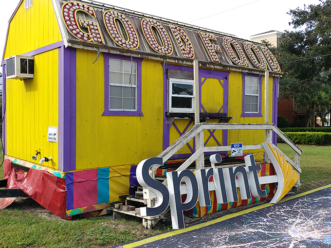 The cheerful yellow "GOOD FOOD" building with its fallen Sprint sign creates a visual poem about corporate castoffs and artistic rebirth.
