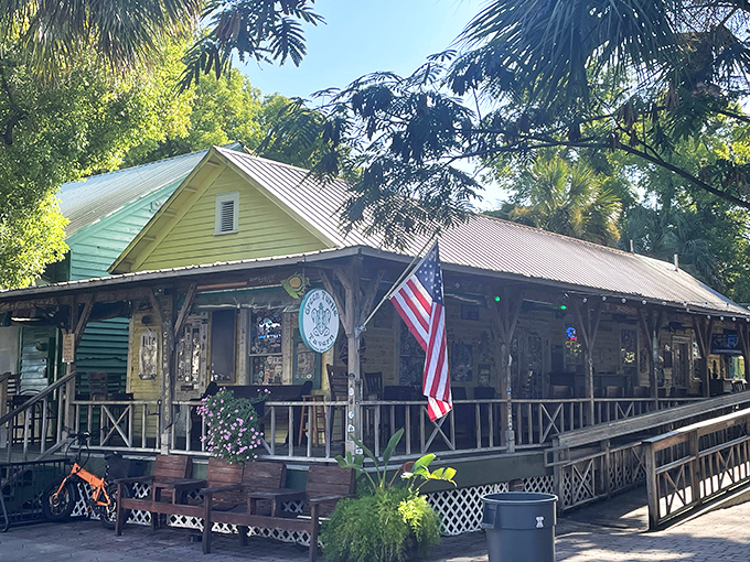 The Green Turtle Tavern embodies old Florida charm with its weathered wooden porch and American flag, promising cold drinks and warm conversations.