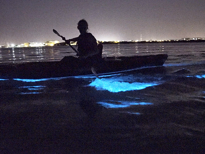 Silhouetted against the night, this kayaker might as well be paddling through the Milky Way itself.