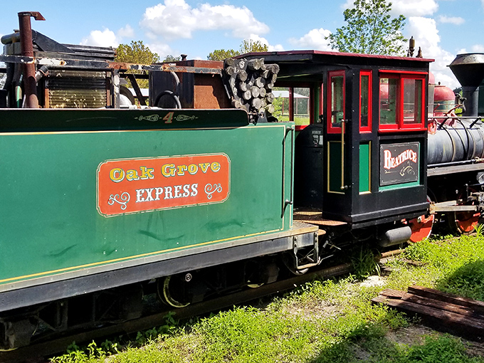 The Oak Grove Express waits for its next journey, its emerald and crimson paint scheme gleaming in the Florida sunshine like a jewel on tracks.