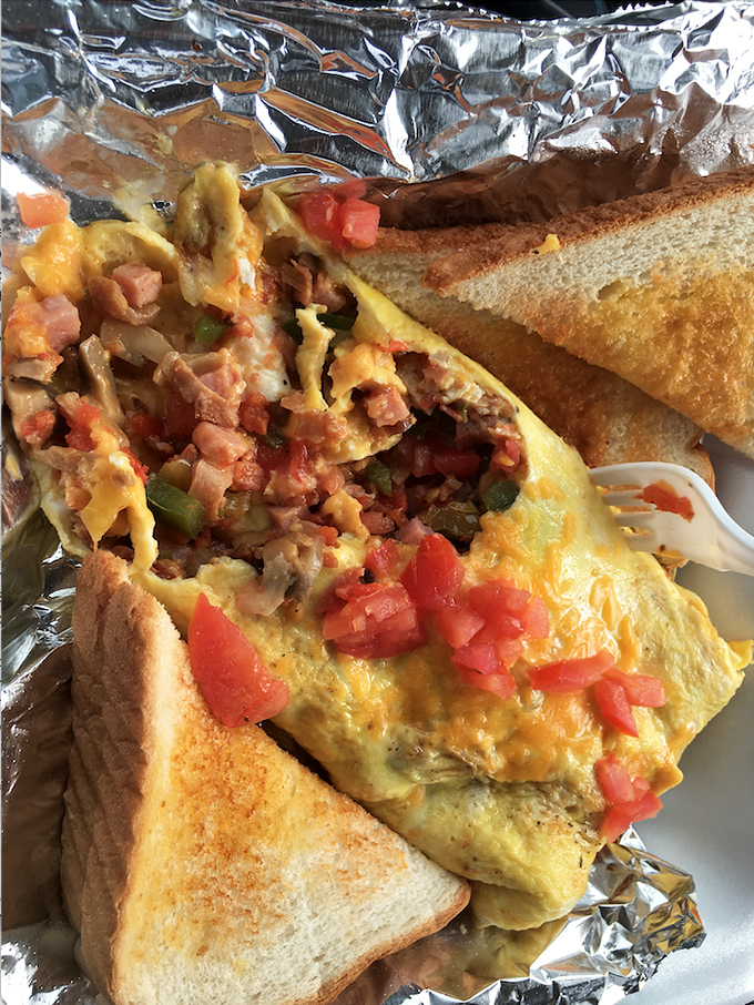 This Western omelet brings together ham, peppers, and cheese in a fluffy egg embrace, topped with fresh tomatoes for that morning wake-up call.