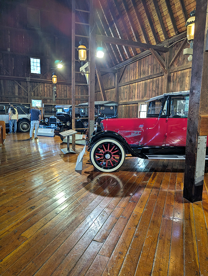 Polished wooden floors reflect vintage automobiles in this converted barn, where agricultural history meets automotive innovation.