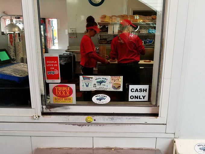 Behind the counter, culinary choreography unfolds as orders are prepared with the practiced precision of people who've turned fast food into an art form.