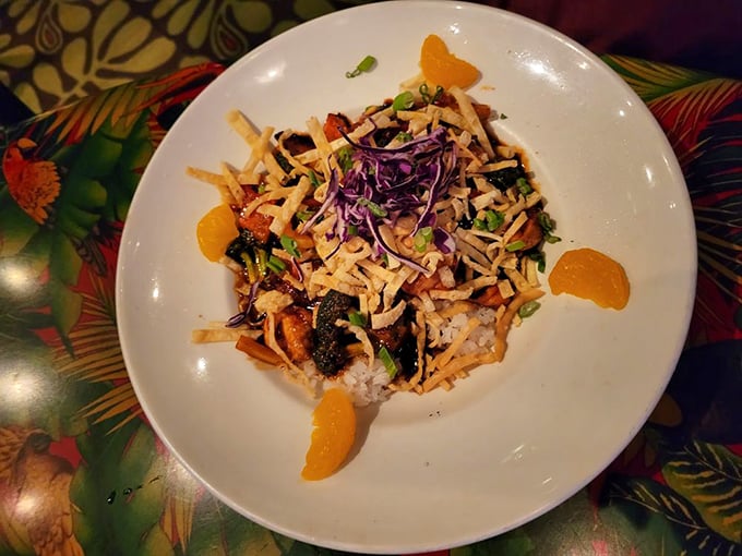 This colorful stir-fry brings together crisp vegetables, tender protein, and mandarin oranges for a sweet-savory combination that pops against the tropical backdrop.