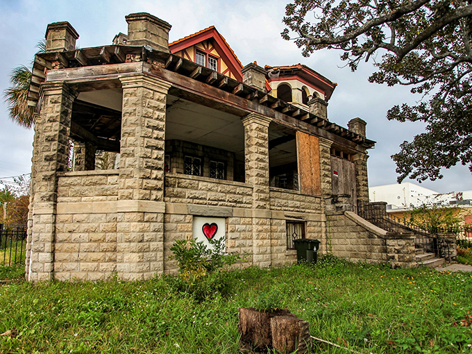 A red heart painted on weathered stone &ndash; modern graffiti meets historic architecture in an unexpected love letter to abandonment.