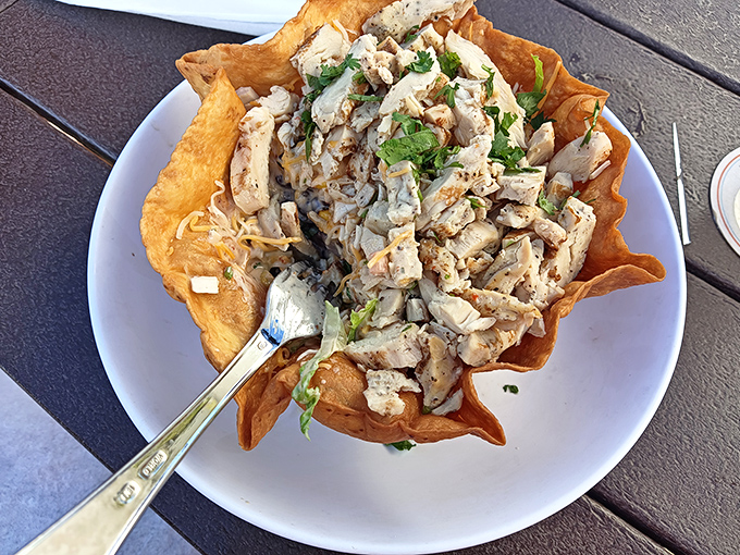 Taco salad reinvented: Crispy shell cradles seasoned chicken and fresh toppings &ndash; fork optional, beach happiness guaranteed.