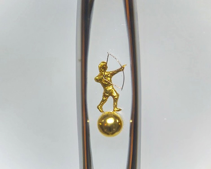 A golden archer balanced on a sphere, viewed through a glass tube &ndash; just one example of the mind-bending miniatures awaiting discovery.