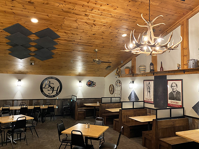 The dining room blends rustic charm with modern comfort, antler chandeliers overhead reminding you this place takes its meat seriously.