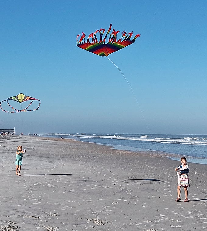 Kites dance on sea breezes like colorful butterflies, their strings connecting earth to sky while children below master the art of flight.