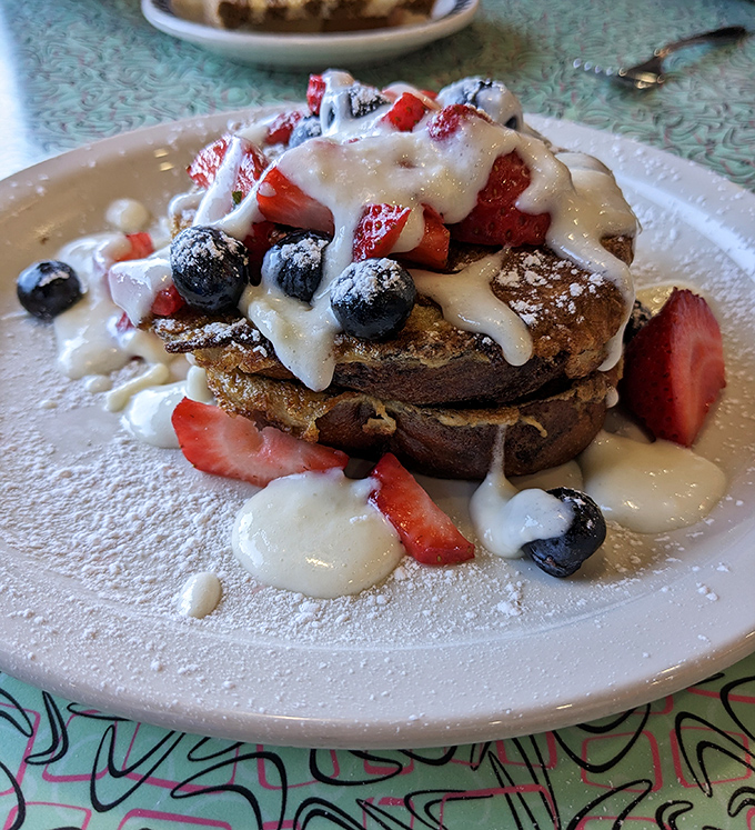 French toast transformed into an art form &ndash; golden bread islands in a sea of berries and cream that makes breakfast feel like dessert.