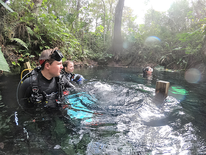 Divers prepare for underwater exploration, their excitement bubbling to the surface more visibly than their air tanks will allow.