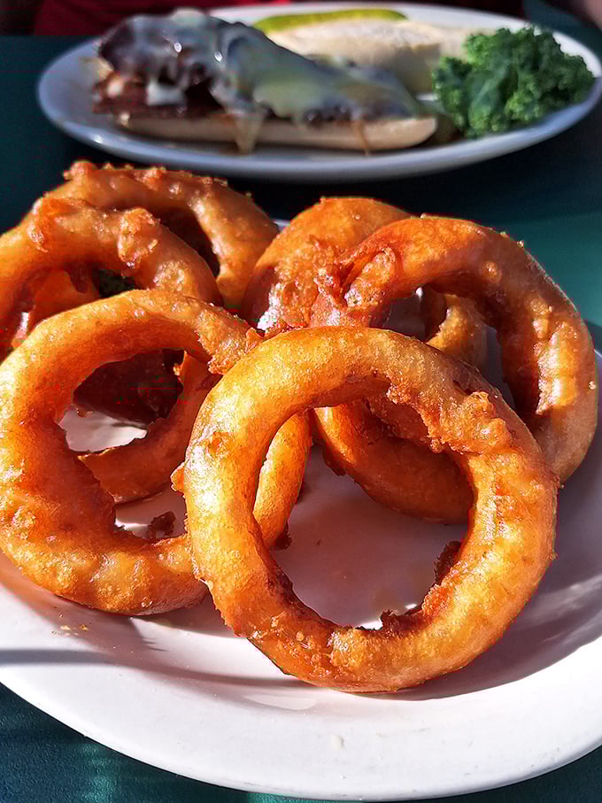 Onion rings that shatter with satisfying crispness &ndash; golden halos of battered delight that make you forget vegetables are supposed to be healthy.