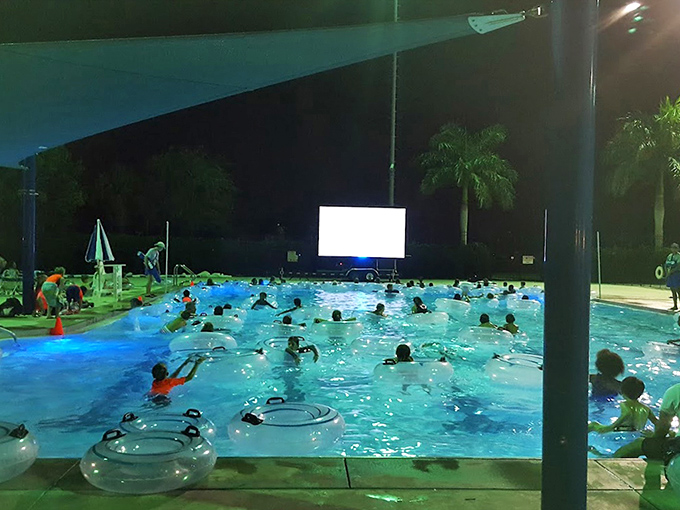 The daytime splash zone transforms into an illuminated water wonderland, proving everything is more magical after dark, especially with floaties.