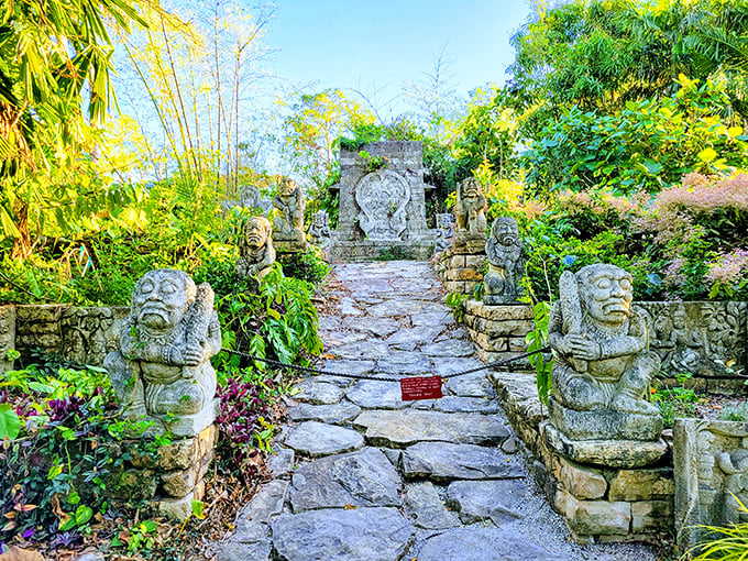 Stone guardians with ancient expressions flank this pathway, creating a mysterious entrance to the hidden wonders of Naples Botanical Garden.