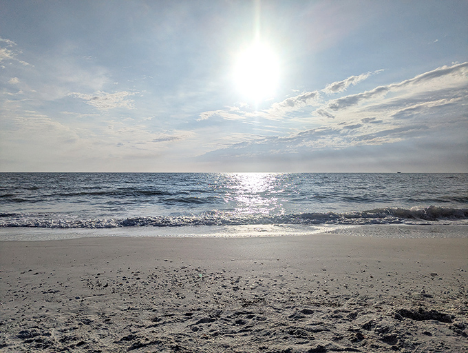White sands and a calm blue horizon create a serene frame for Keewaydin Island's untouched beach experience.